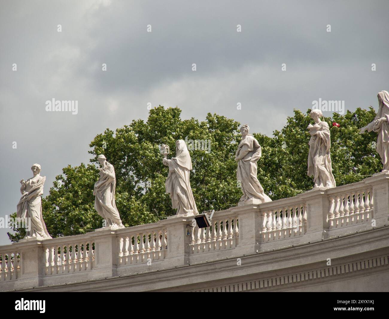 Statues on columns under cloudy sky with green background in classical ...