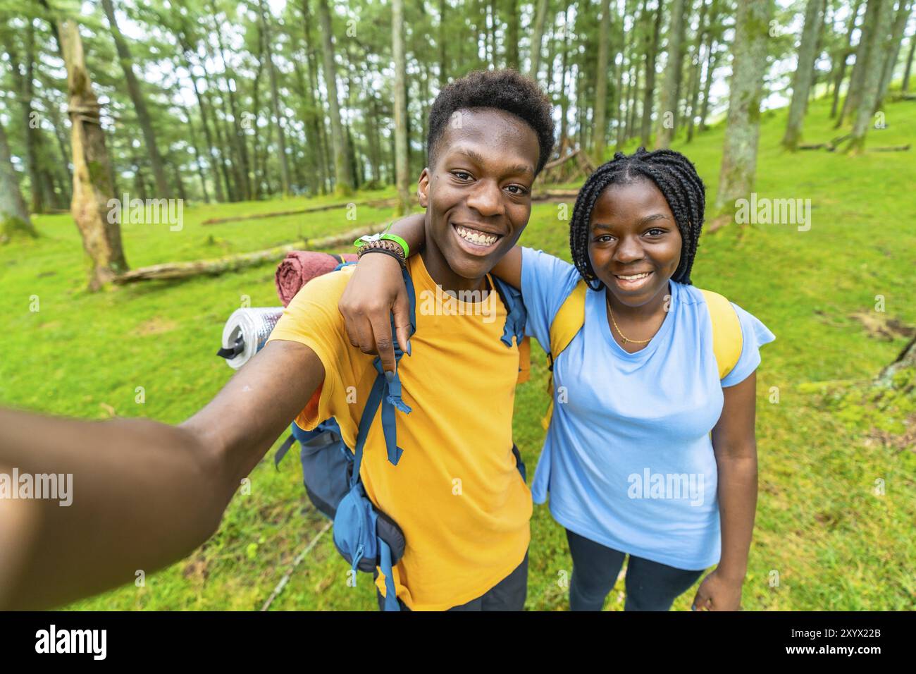 African friends smiling while taking a selfie hiking in the forest ...