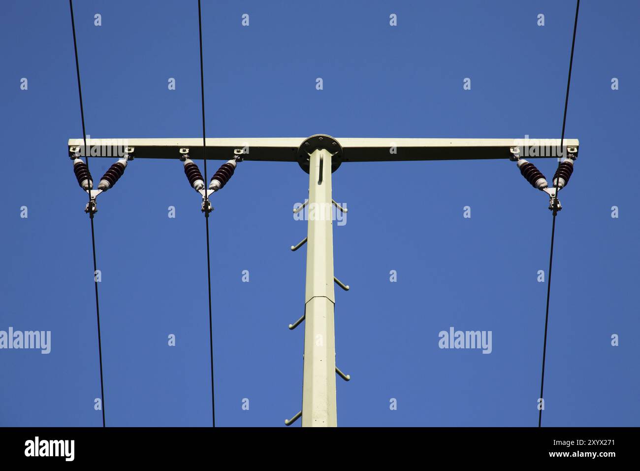 Overhead electricity pylon in front of a blue sky Stock Photo - Alamy