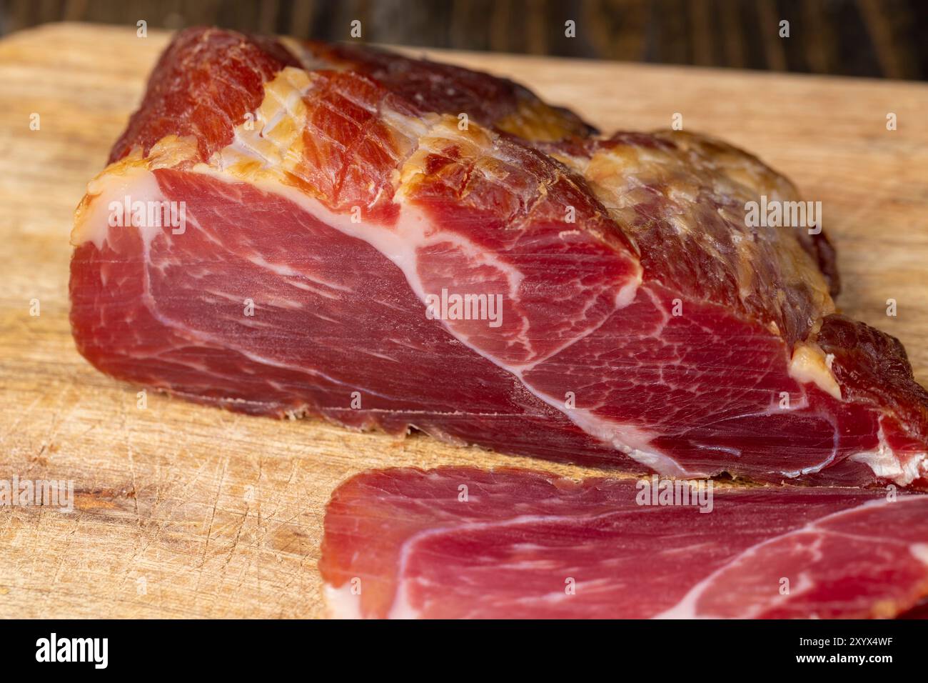 pork ham, a close-up of a piece of cured pork ham with thin layers of ...