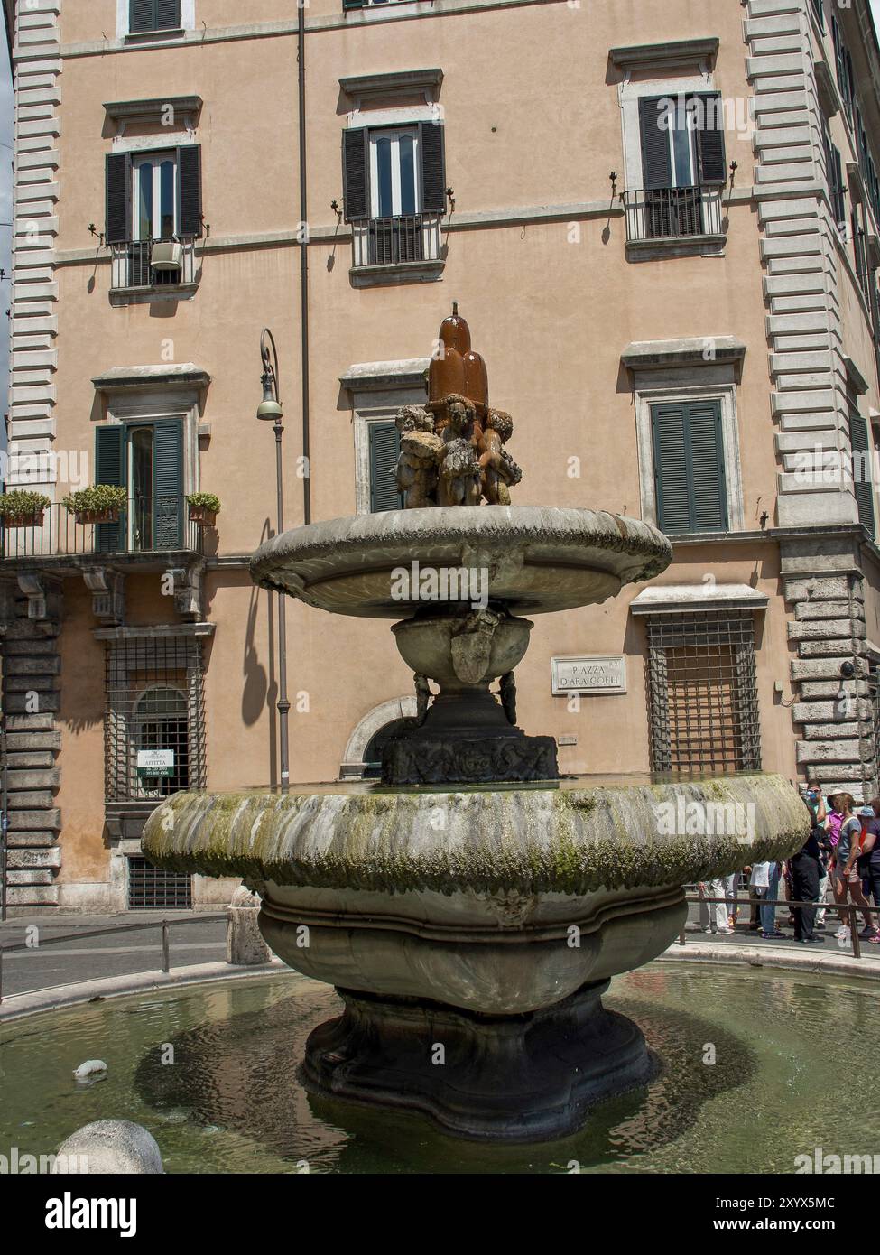 Historic fountain in front of a multi-storey building under a clear sky ...