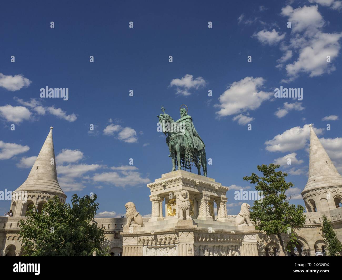 Equestrian statue and towers in front of a bright blue sky with few ...
