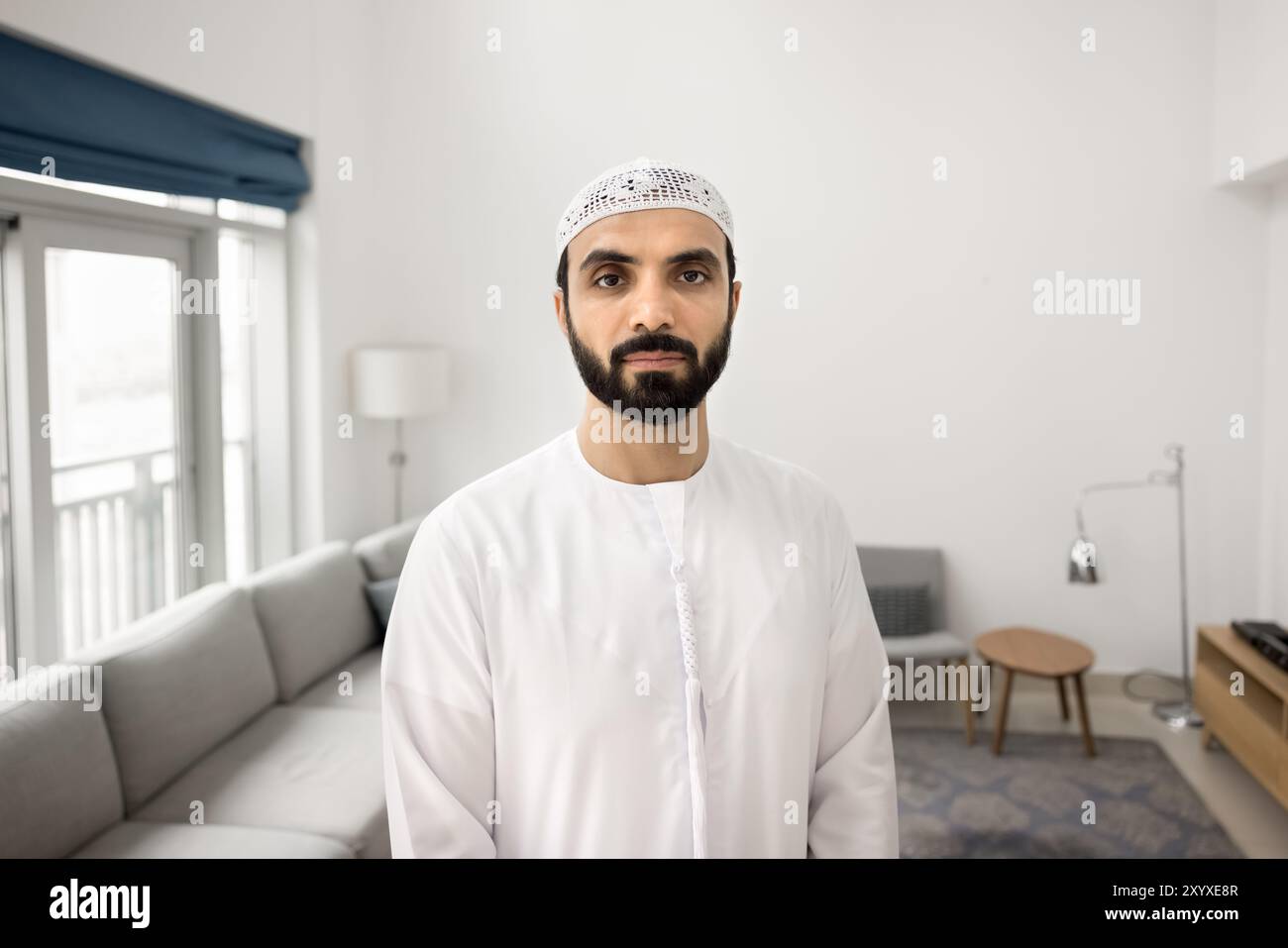 Serious middle aged Arabic man standing in living room Stock Photo - Alamy