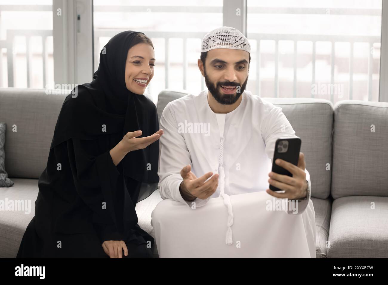 Happy Muslim Arabian couple talking on cellphone on video call Stock ...