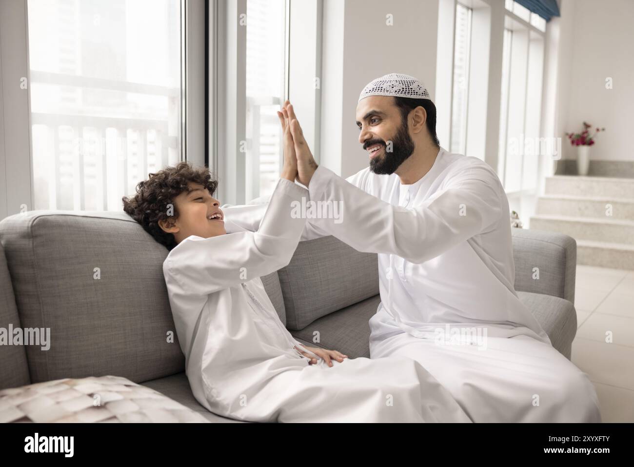Happy Muslim father giving high five to cheerful little son Stock Photo ...