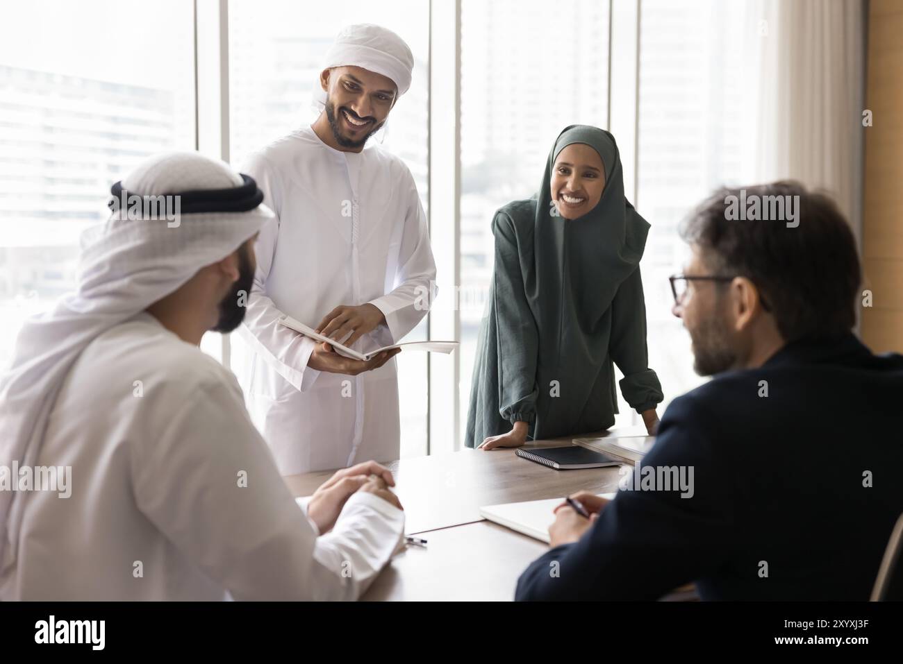 Successful happy diverse Arabic project colleagues talking at table ...