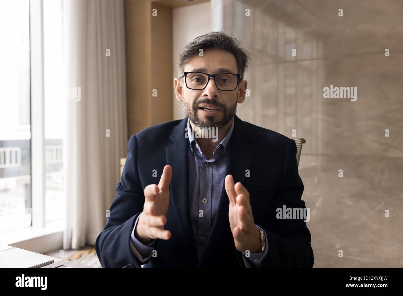 Serious Hispanic business professional man talking on video call Stock ...