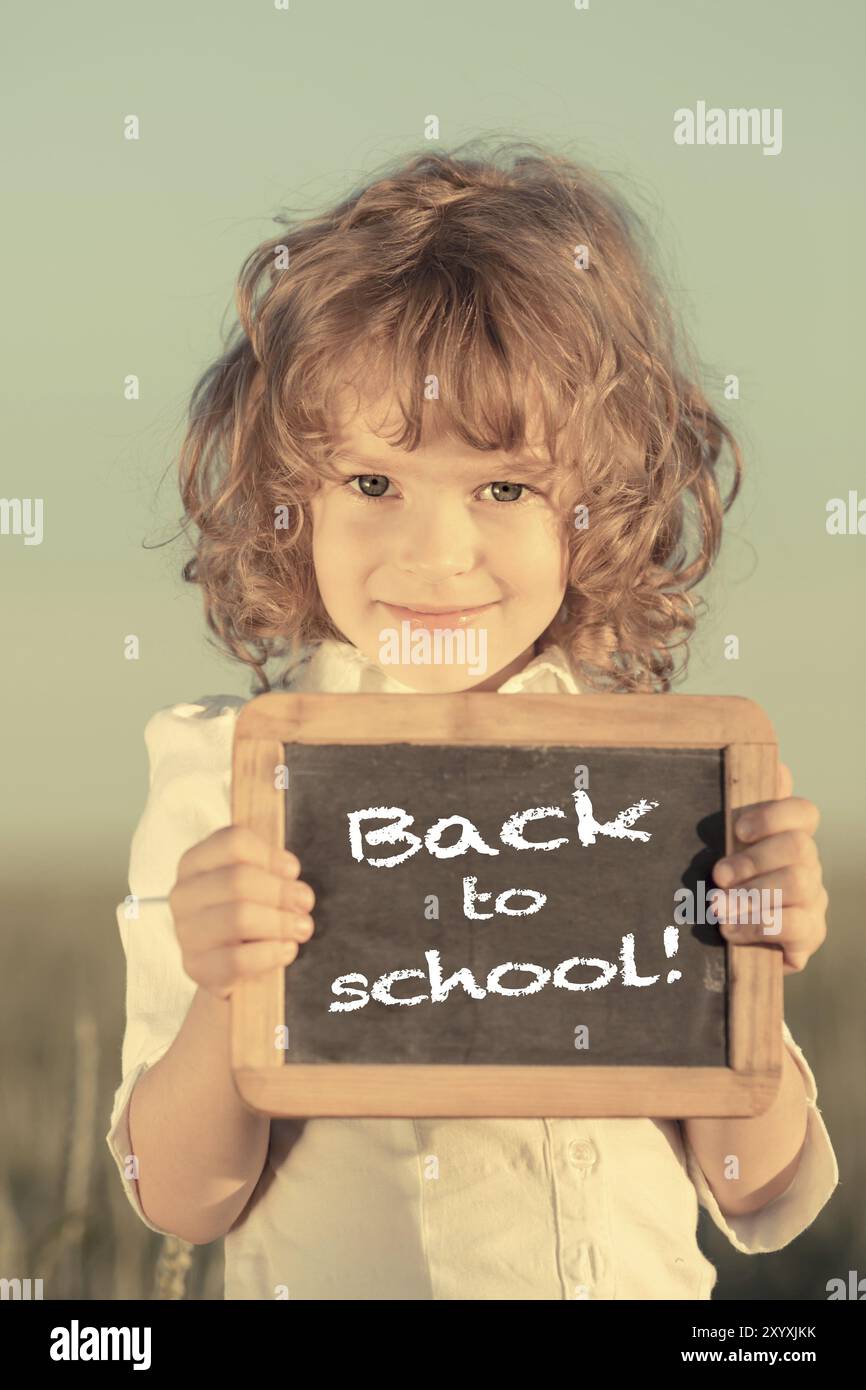 Happy smiling schoolchild holding small blackboard with text Stock ...