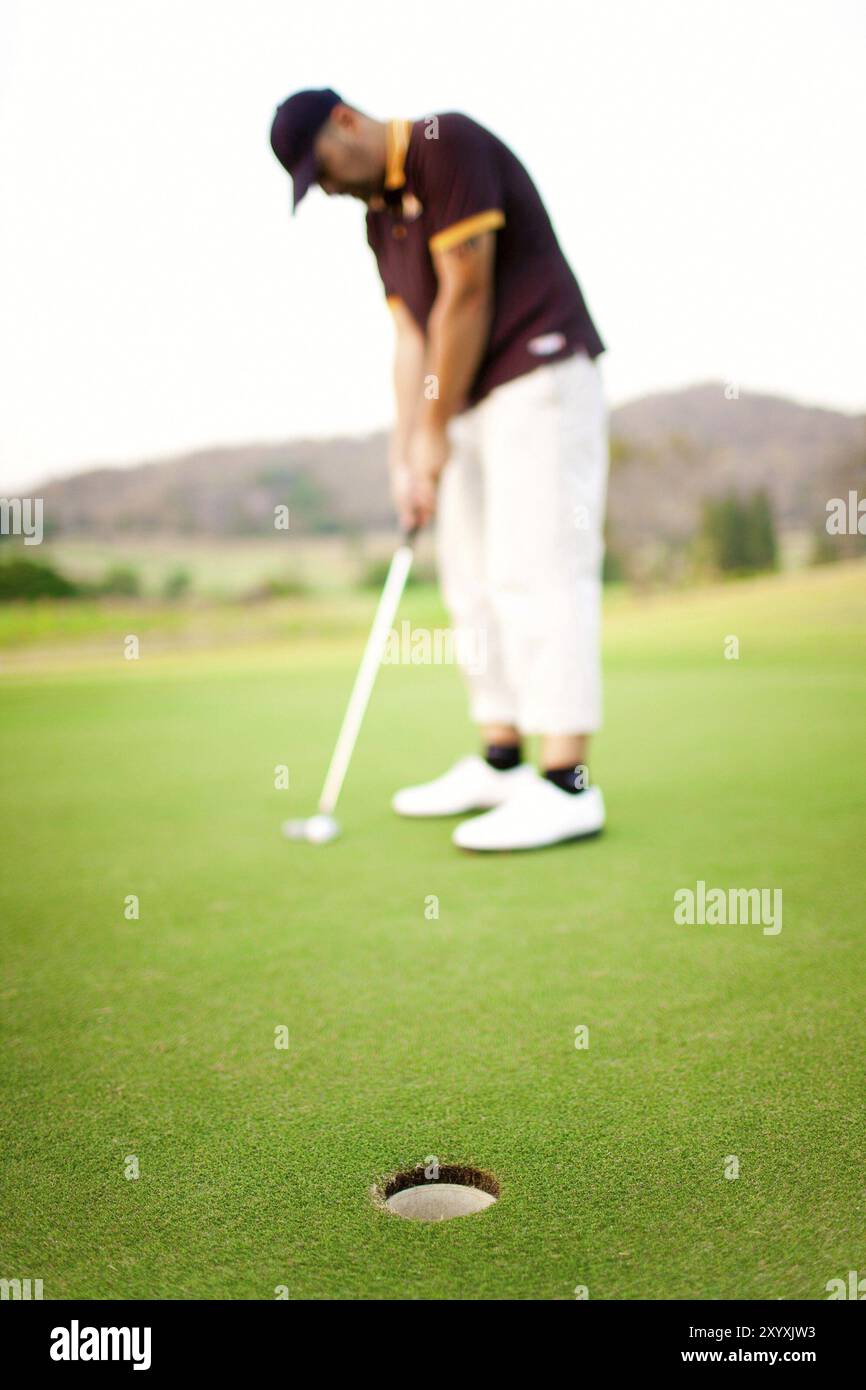 Young golfer doing putt shot Stock Photo - Alamy