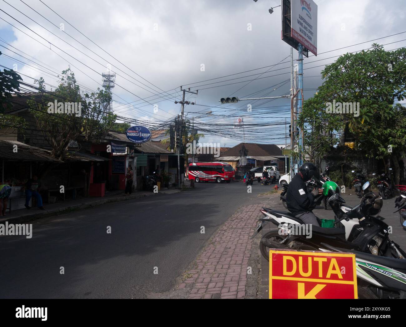 Urban street scene in Bali, Indonesia with motorcycles, local shops and ...