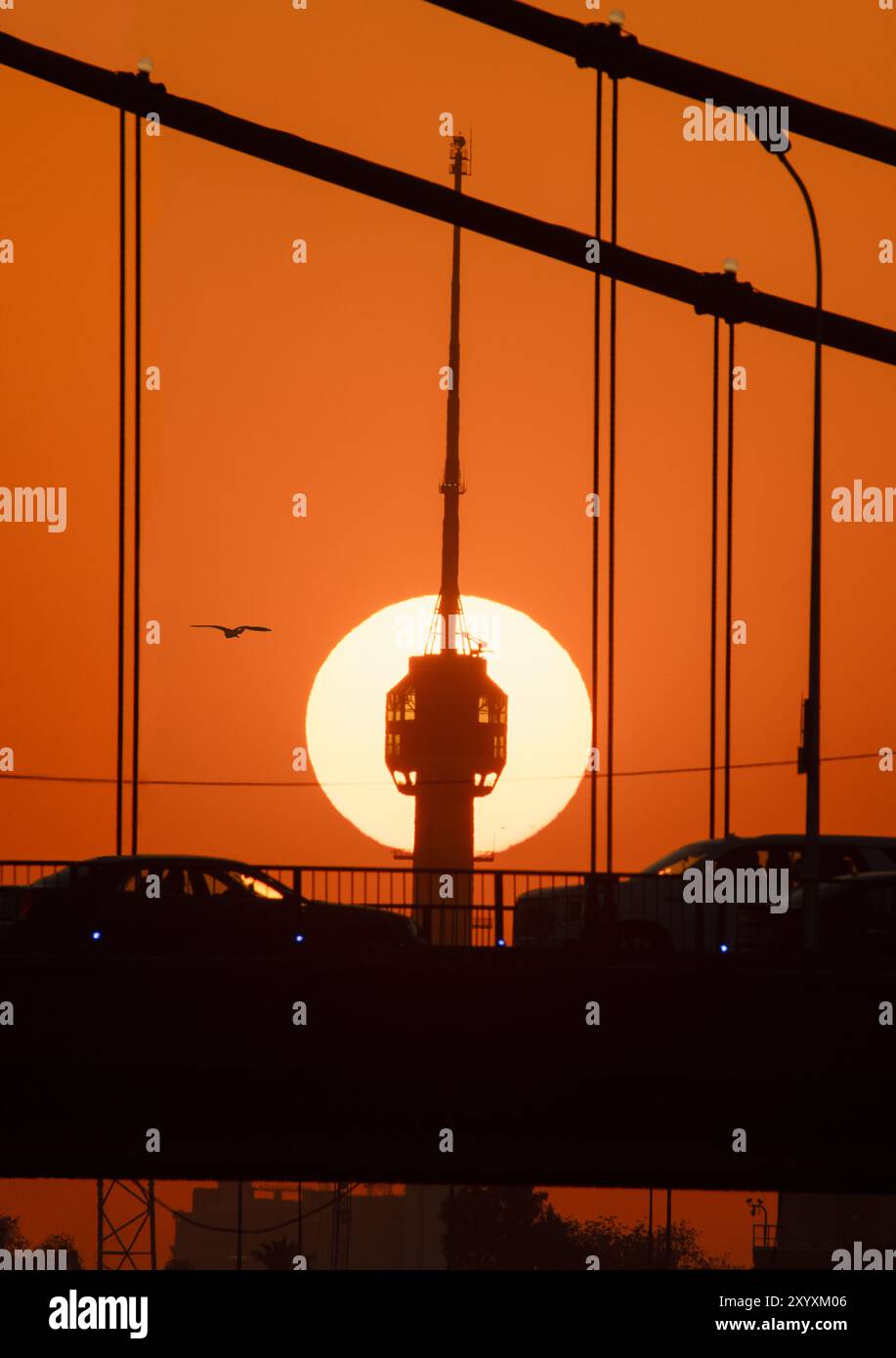 Sun sets behind Baghdad Tower and part of the Suspension Bridge in ...