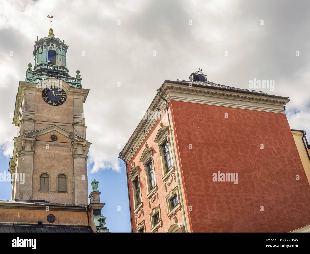 Historic tower with clock next to another building, sky with some ...