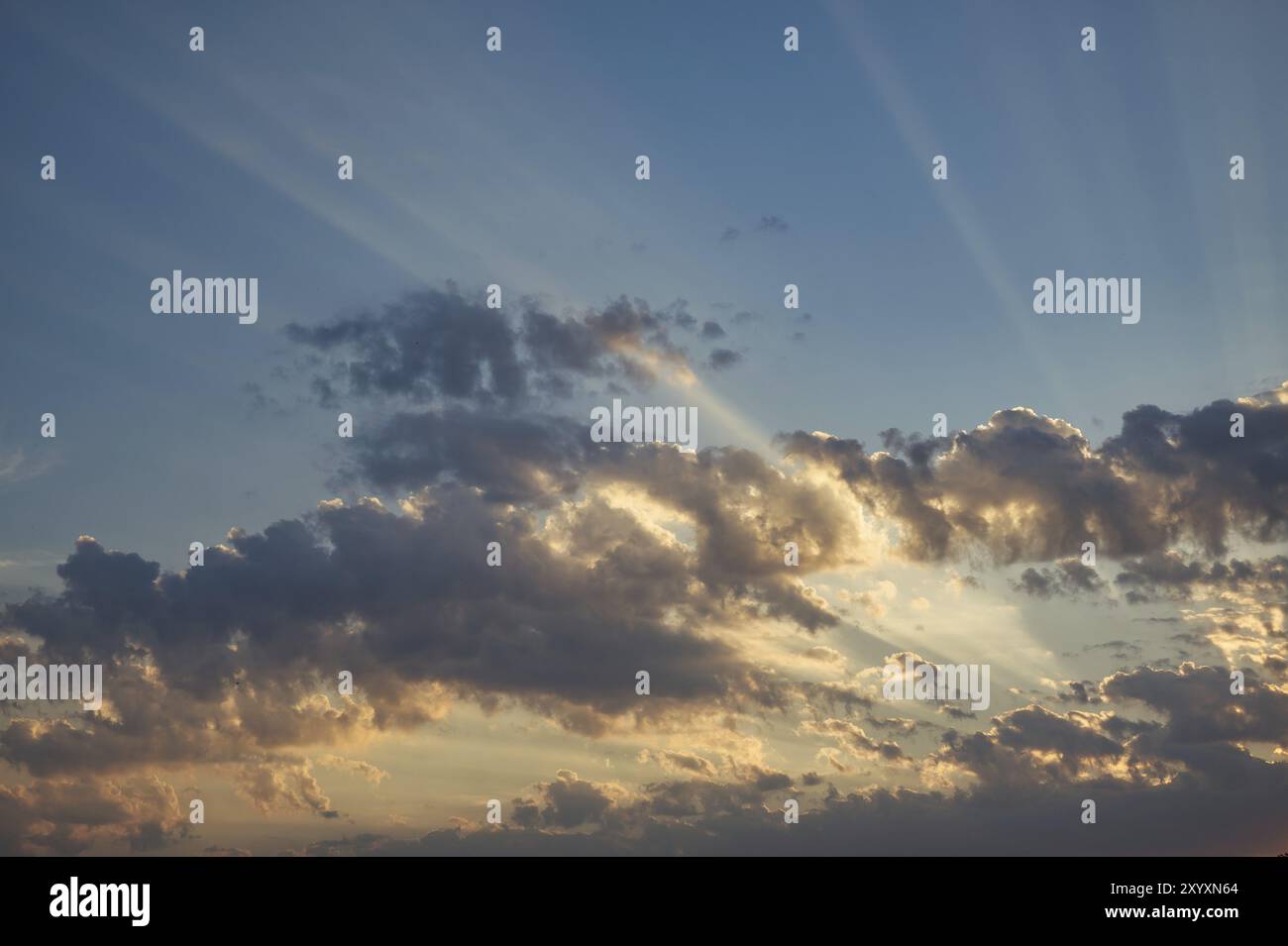 The sky is illuminated with a golden-orange hue, as the sun peeks ...