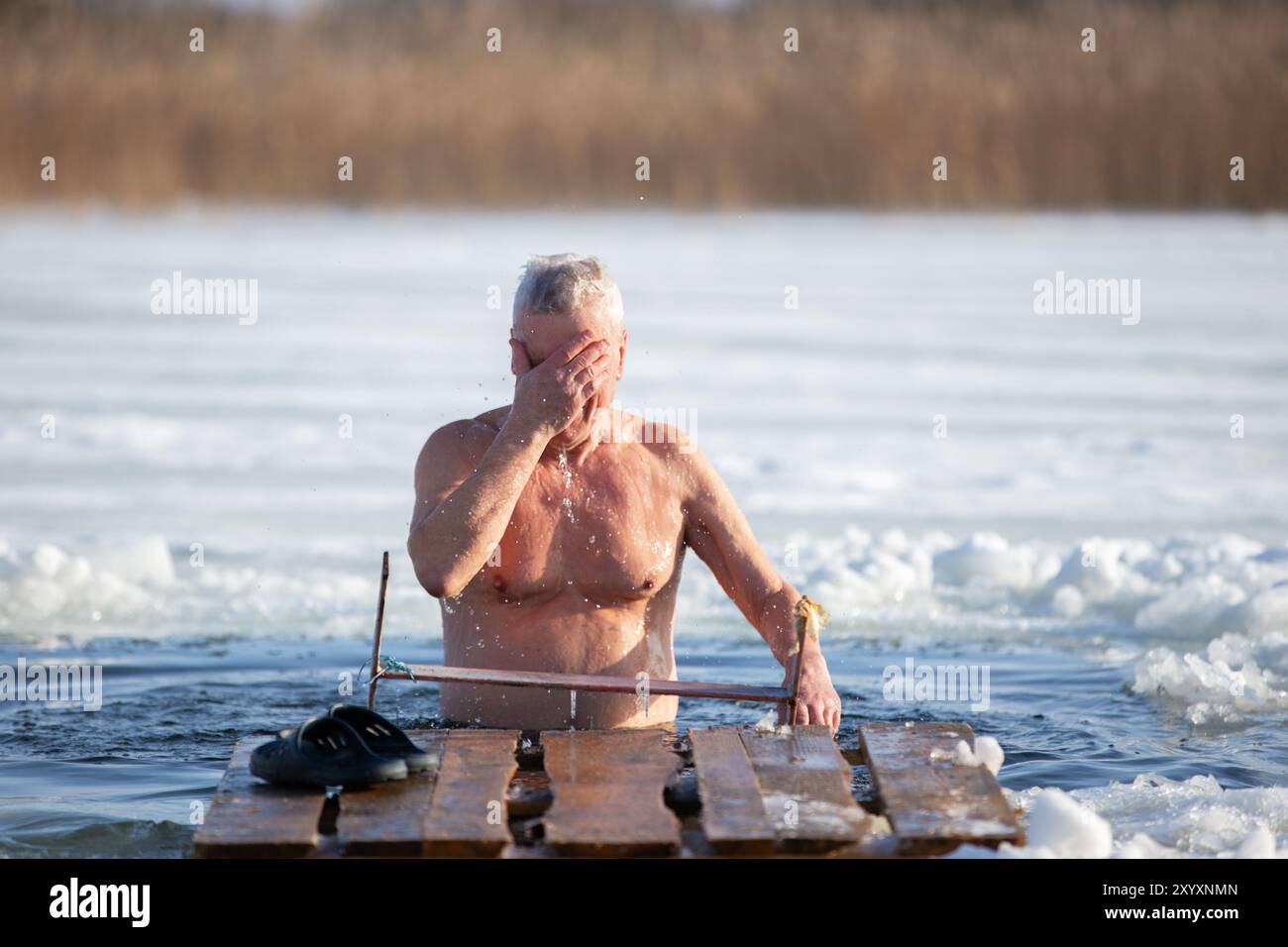 An elderly man bathes in an ice hole on the Orthodox feast of the ...