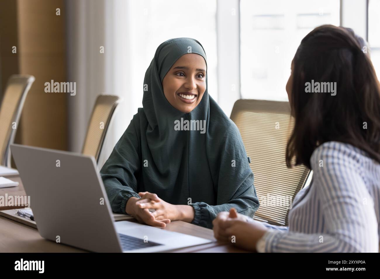 Happy young Arab business professional woman talking to colleague Stock ...