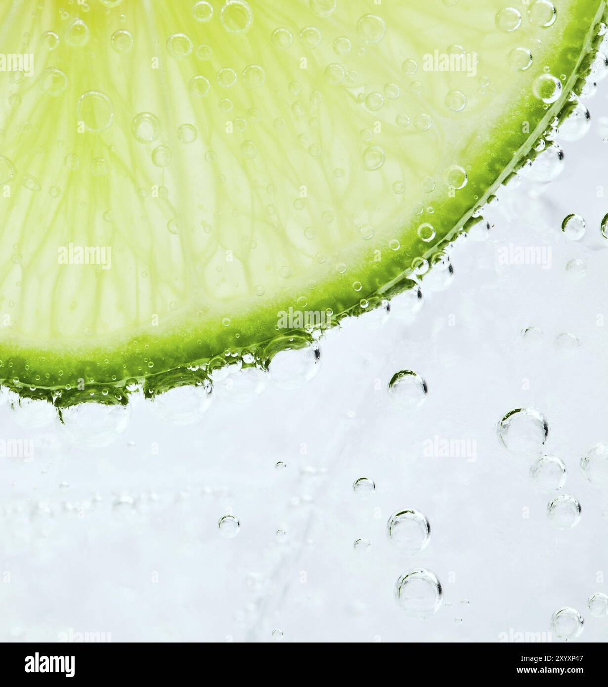 Lime floating in sparkling water Stock Photo - Alamy