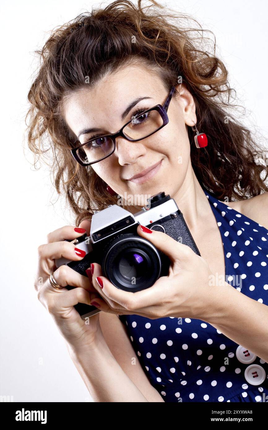 Beautiful woman in a blue polka dot dress with camera Stock Photo - Alamy