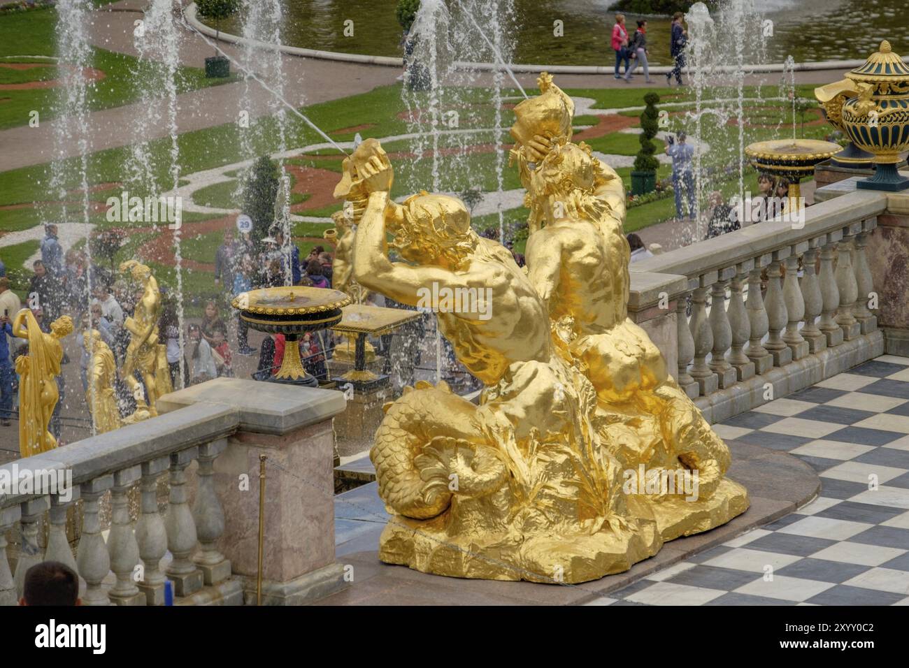 Golden statues in a flowing water feature in a garden with visiting ...