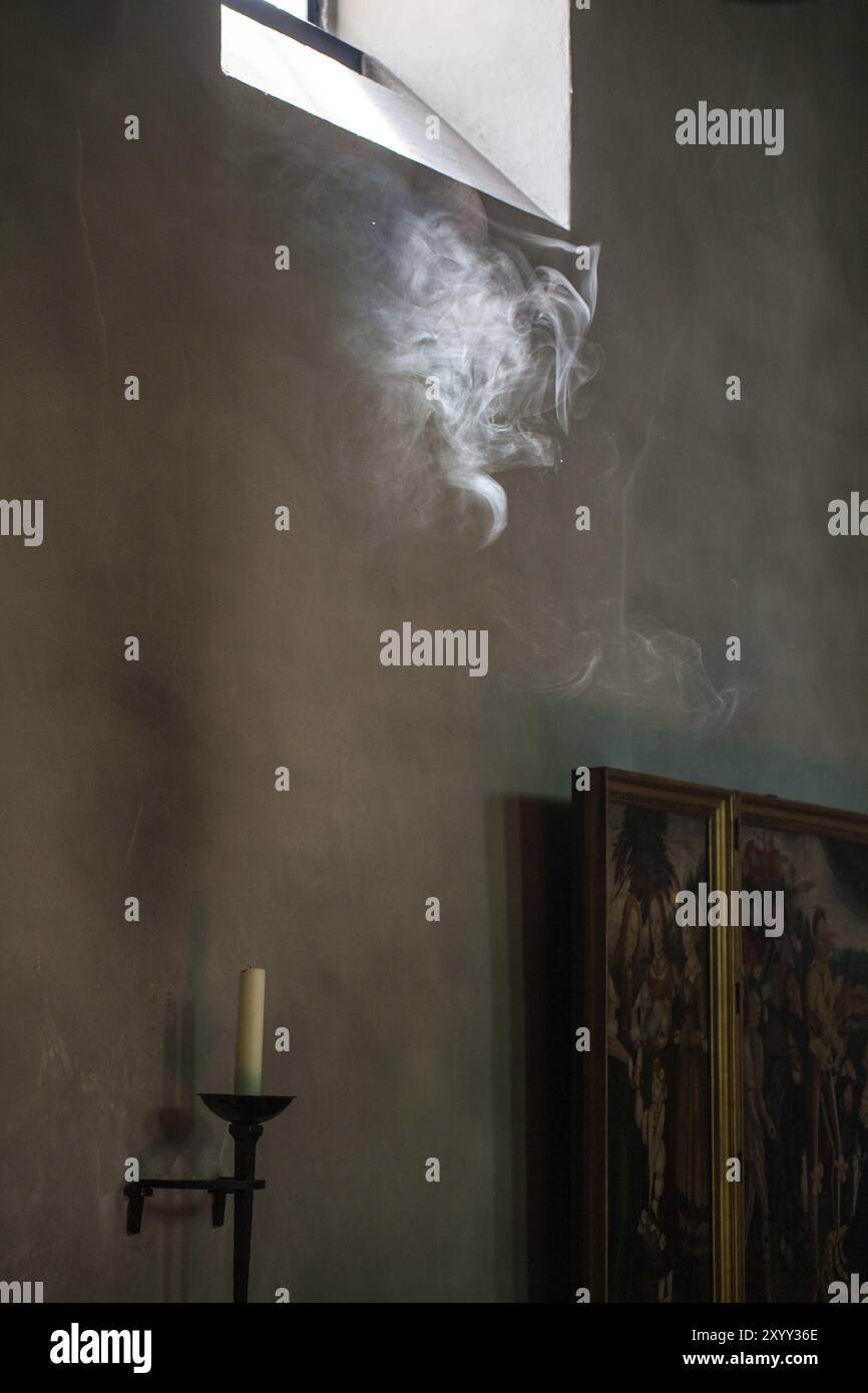 Smoke rising from a blown-out candle to a church window Stock Photo - Alamy