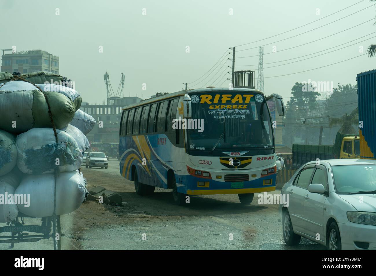 Dhaka, Bangladesh - 05.16.2023: A busy city street with a yellow and ...