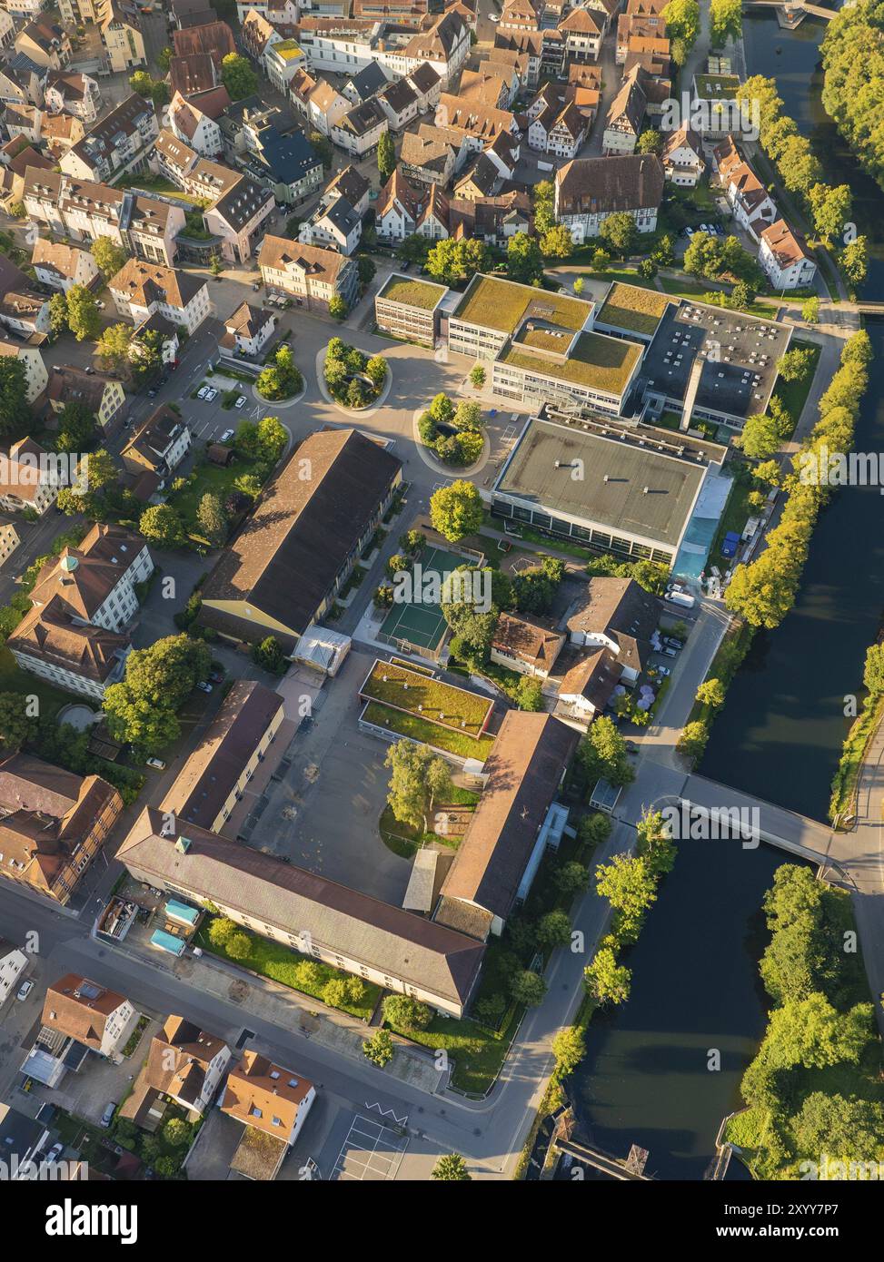 Aerial view of a town with buildings, streets and a river, surrounded ...
