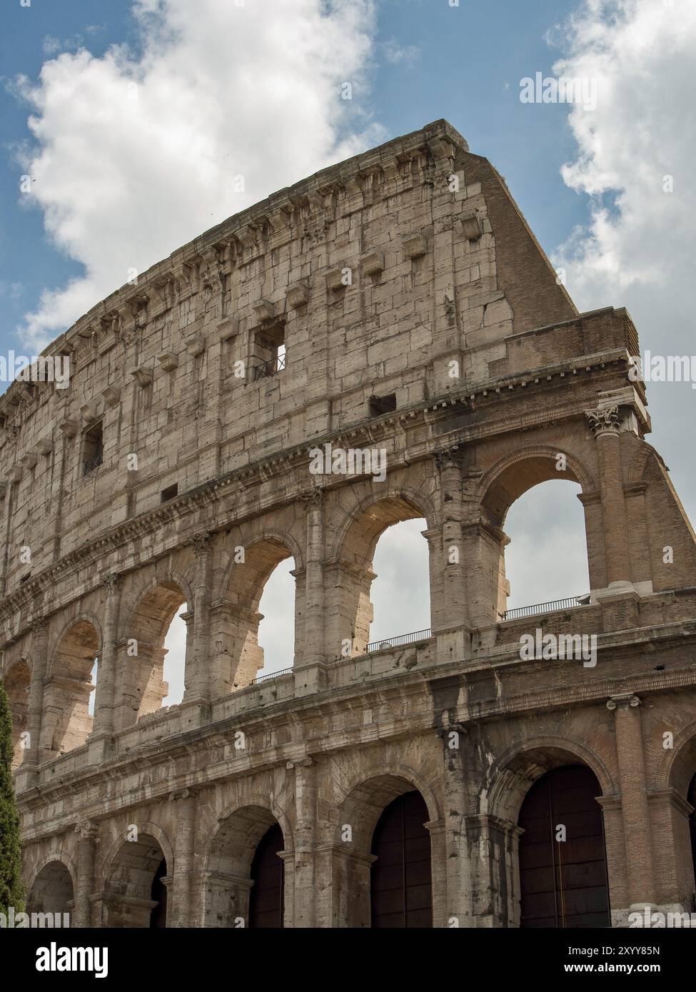 Historic Colosseum with high arcades and old stones under a partly ...