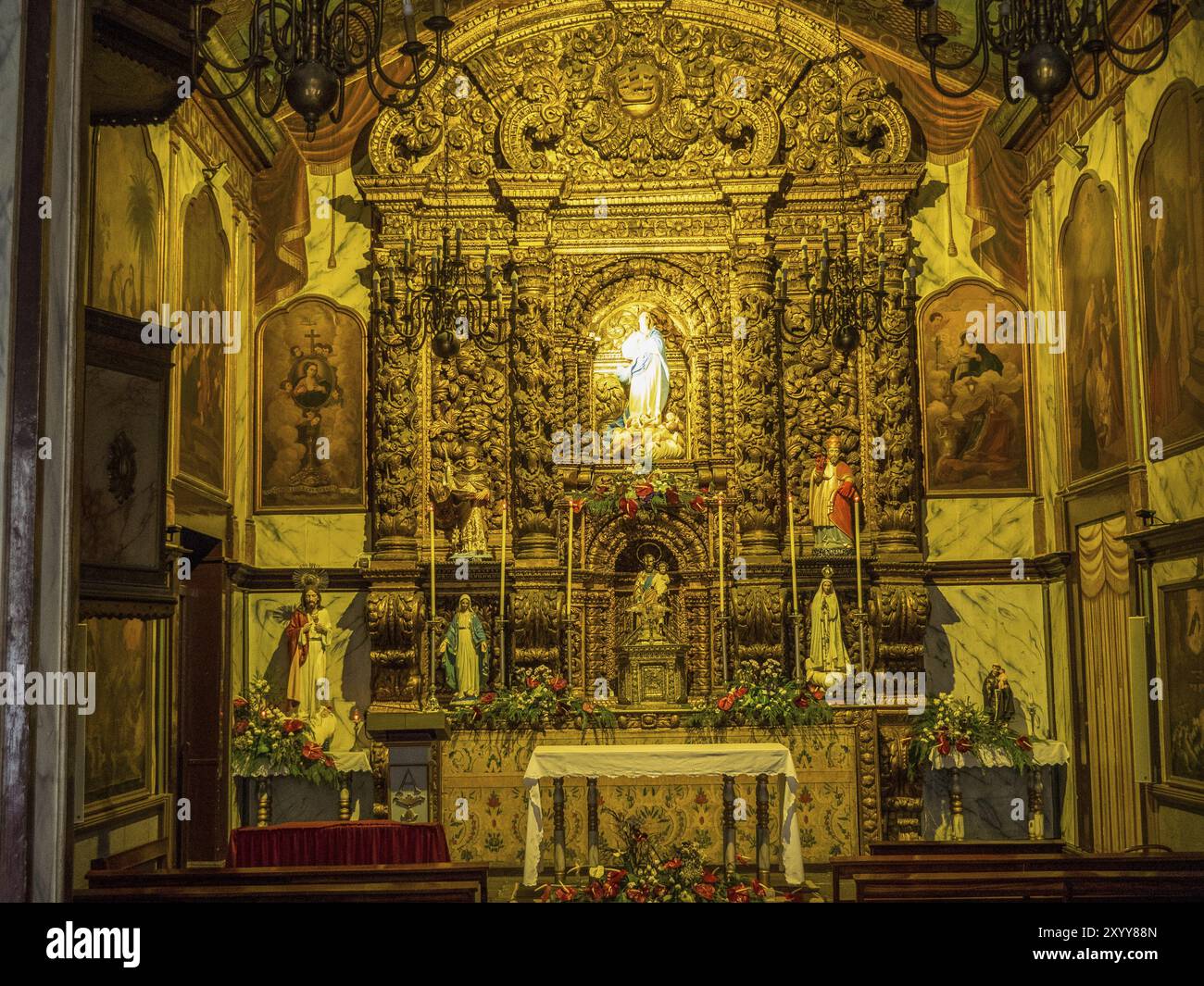 Magnificent church altar with statues of saints, candles and ornate ...