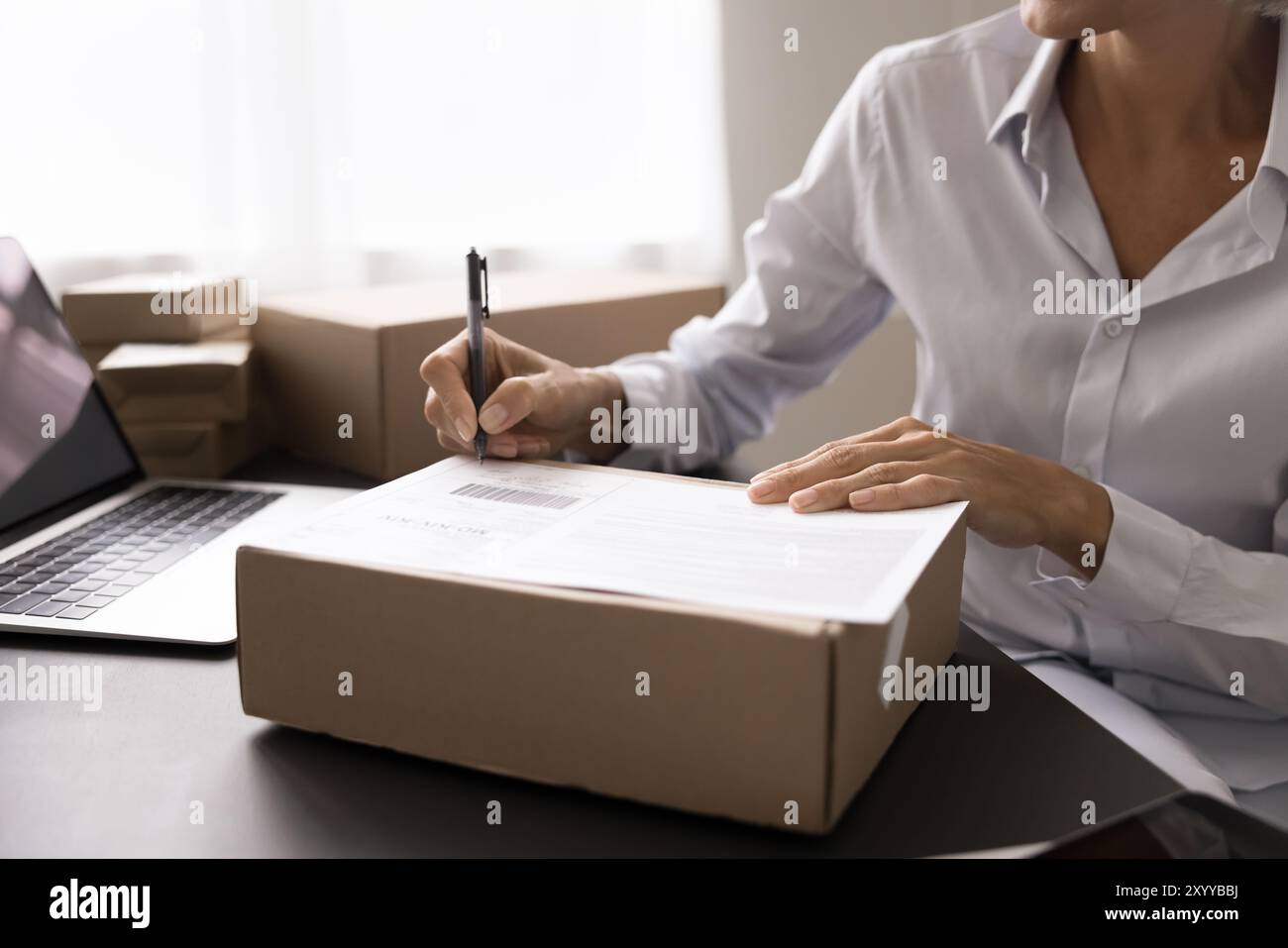 Warehouse worker writing shipping address on delivery box Stock Photo ...
