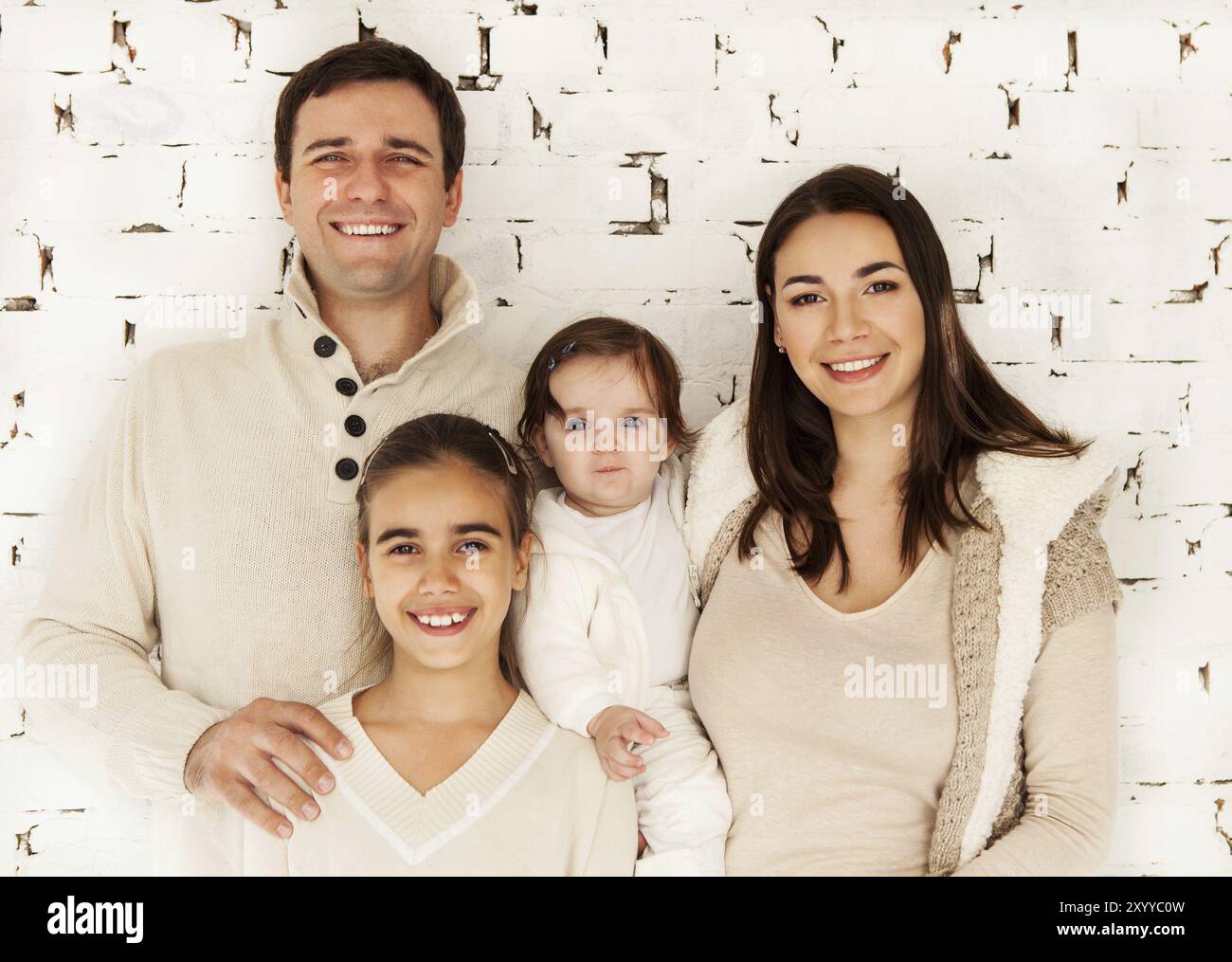 Portrait of a happy smiling family near white brick wall Stock Photo ...