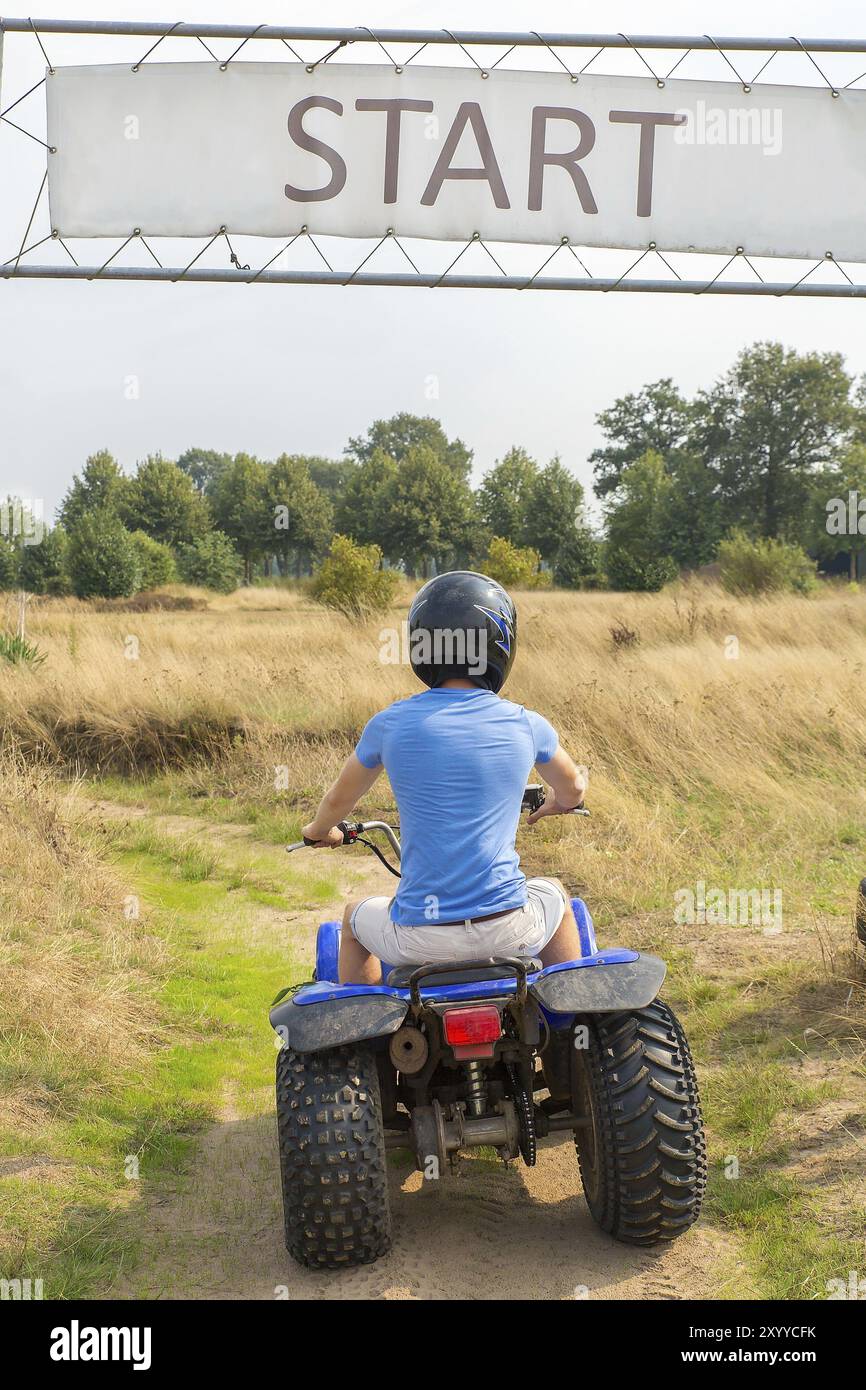 Young dutch man driving quad at starting point Stock Photo - Alamy