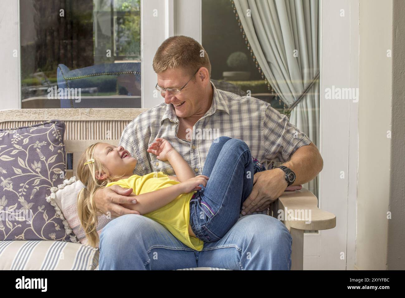 A father and daughter spending fun time together outside on the porch ...