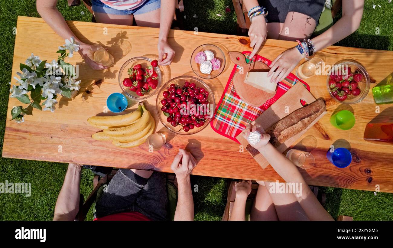 Family and friends eating together outdoors on summer garden party ...