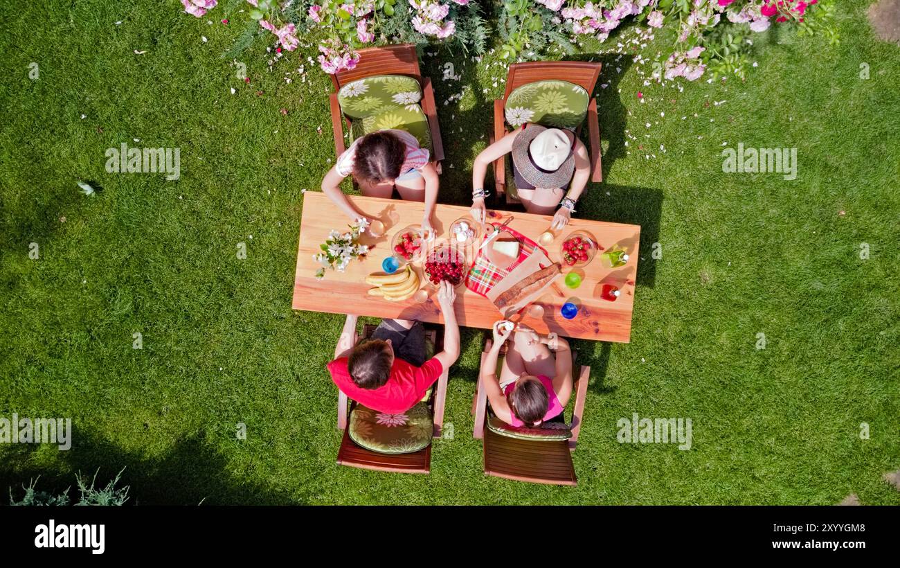 Family and friends eating together outdoors on summer garden party ...