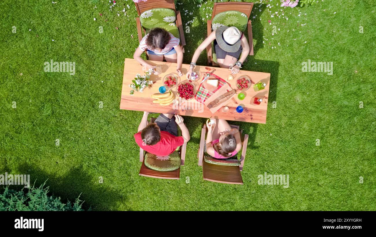Family and friends eating together outdoors on summer garden party ...