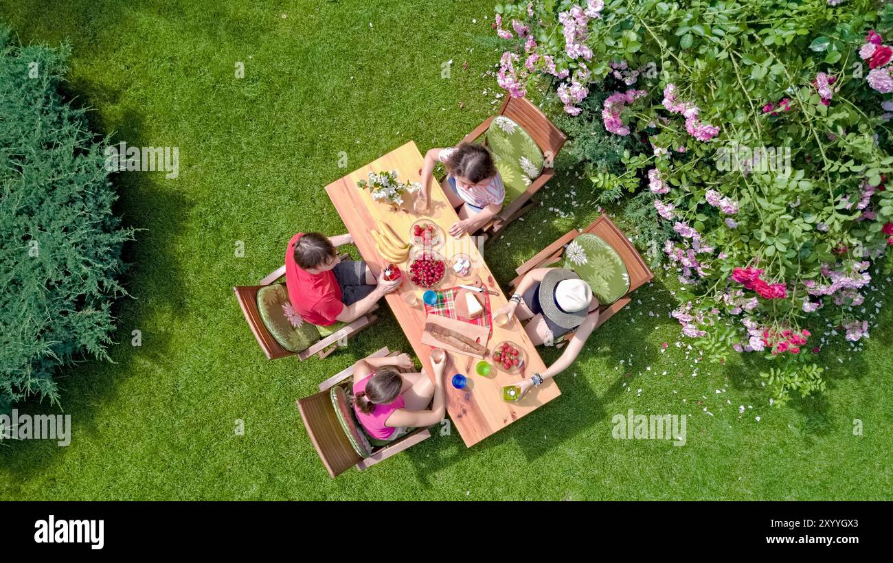 Family and friends eating together outdoors on summer garden party ...