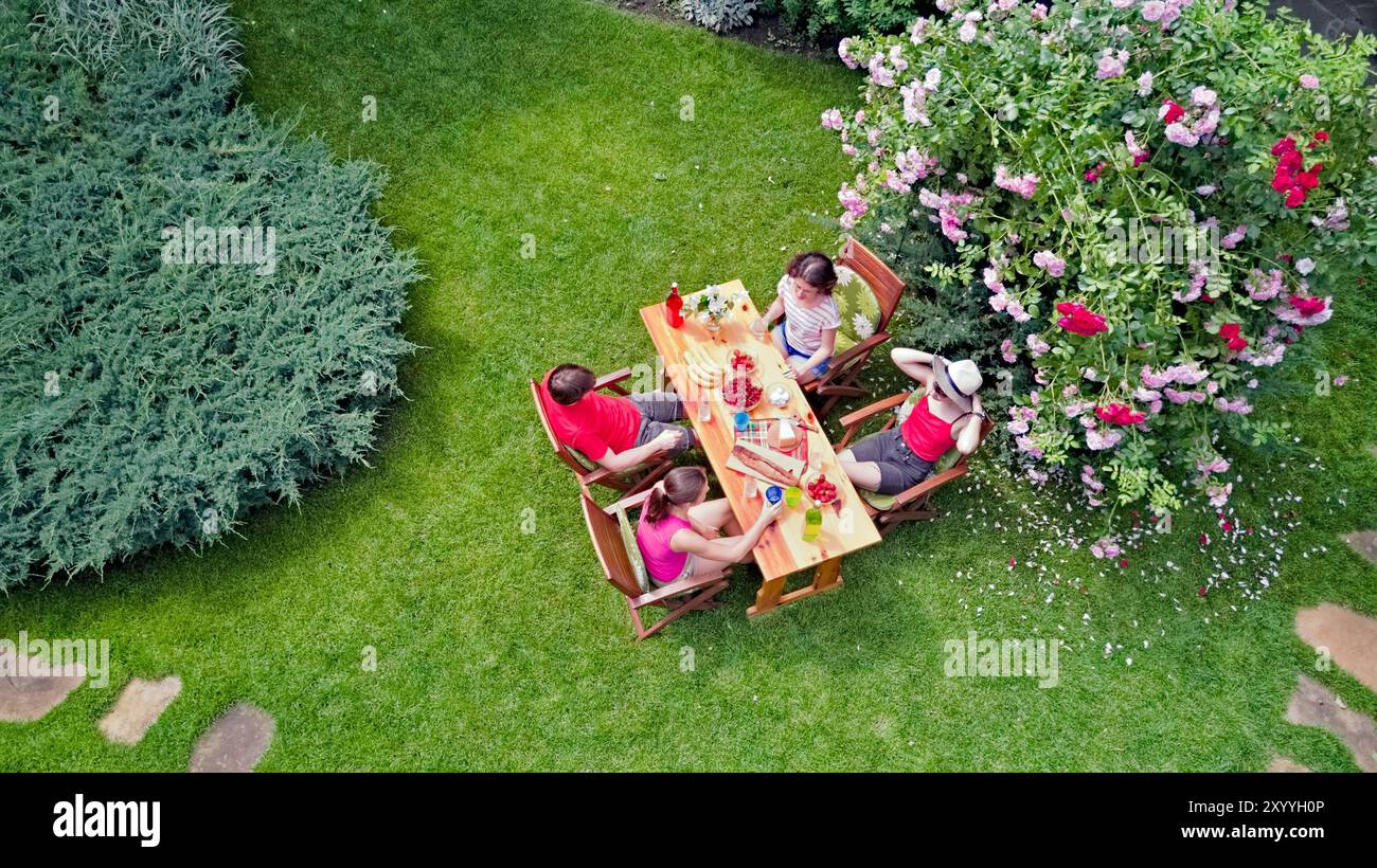 Family and friends eating together outdoors on summer garden party ...
