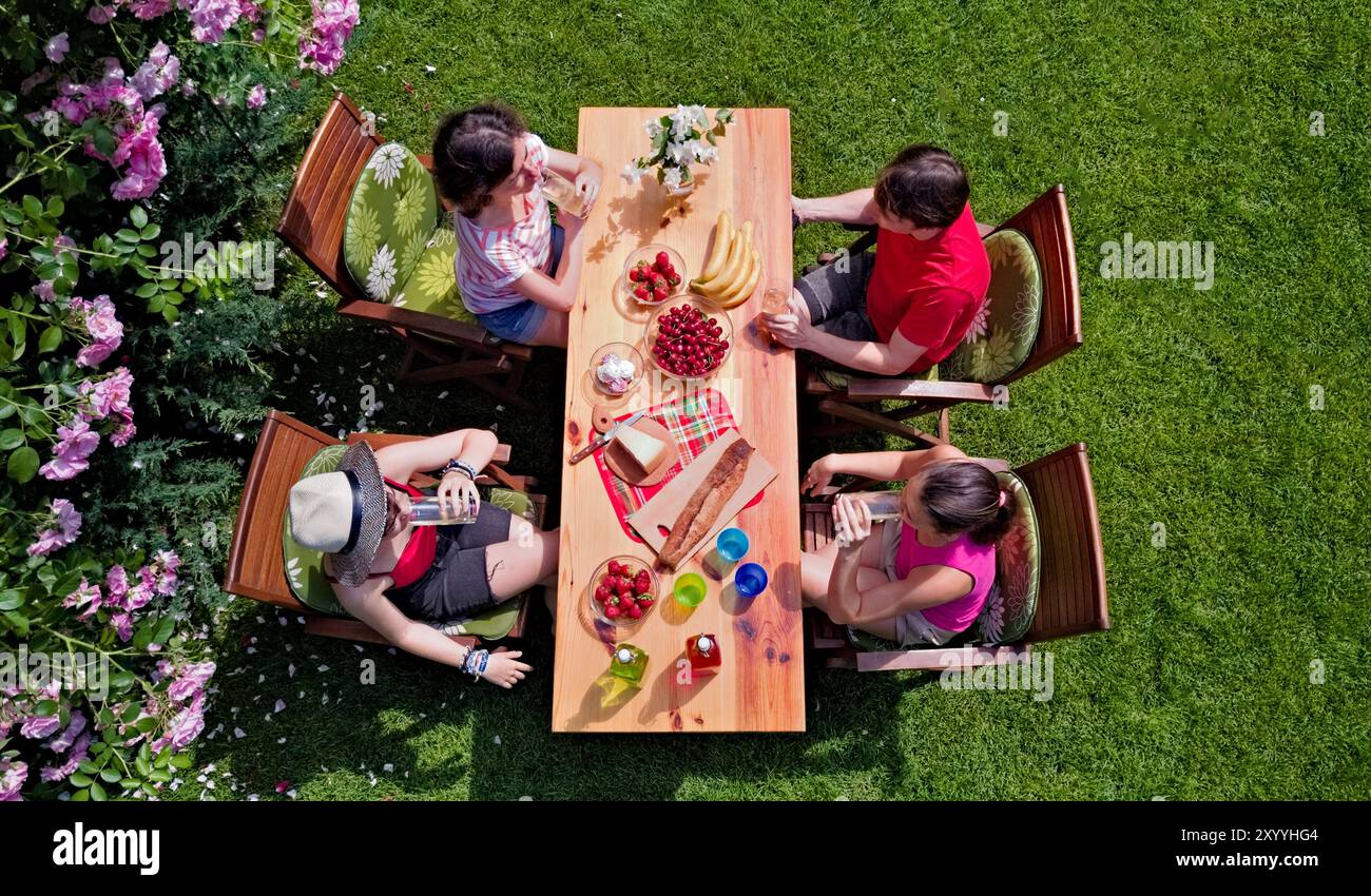Family and friends eating together outdoors on summer garden party ...