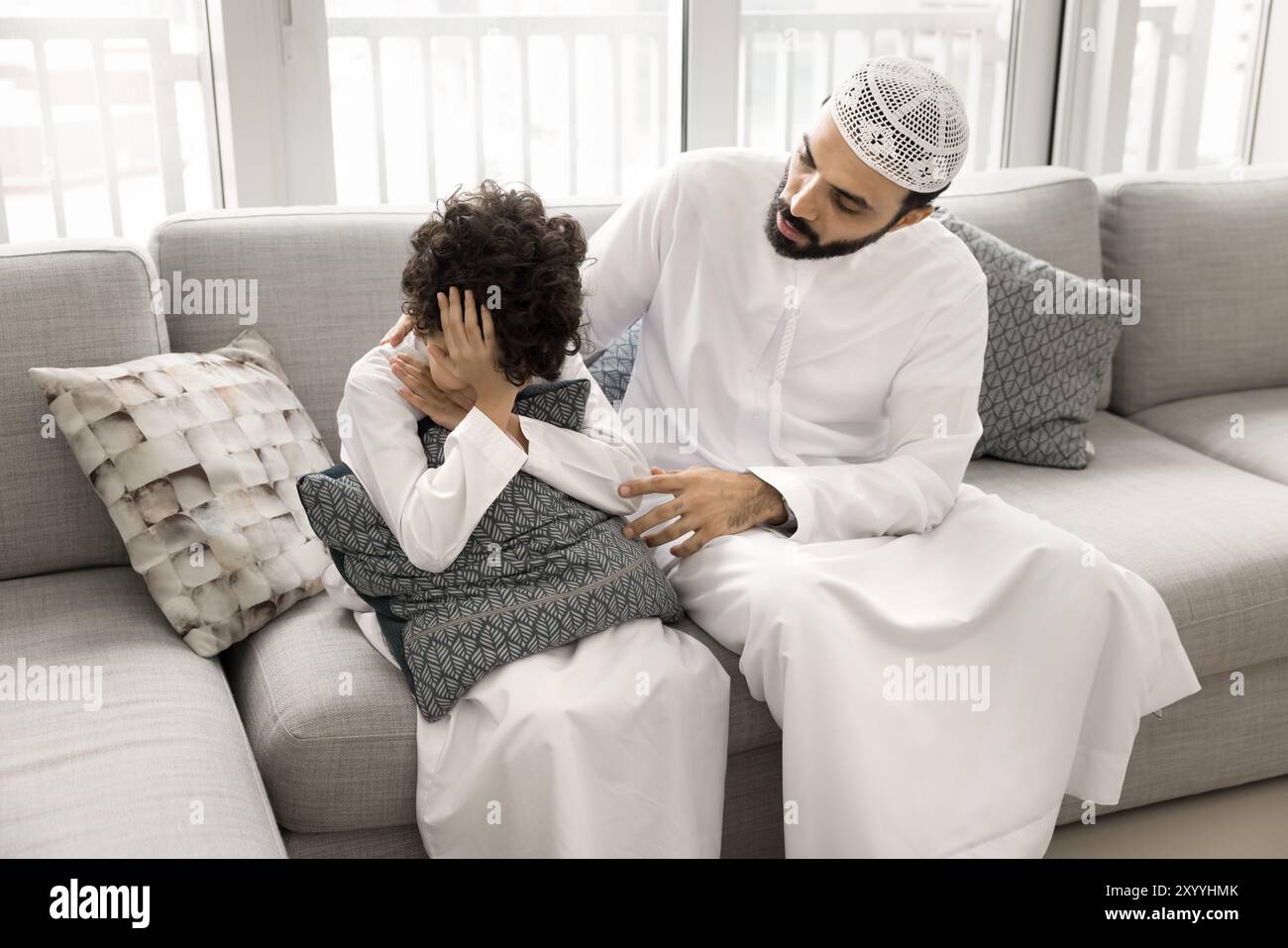 Serious concerned Arabian dad talking to crying little son kid Stock ...