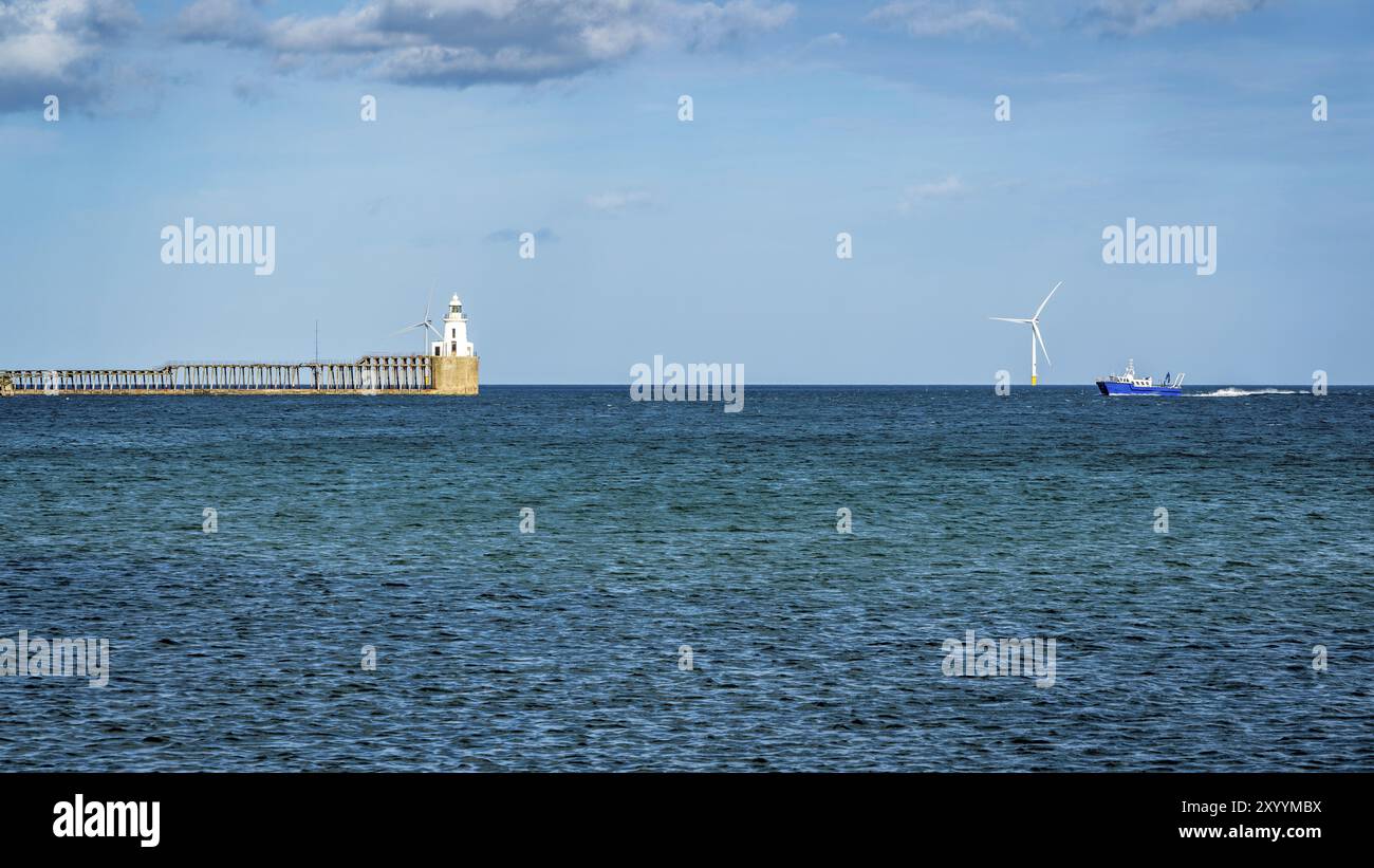 Blyth Lighthouse, the pier and a wind turbine on the North Sea Coast ...