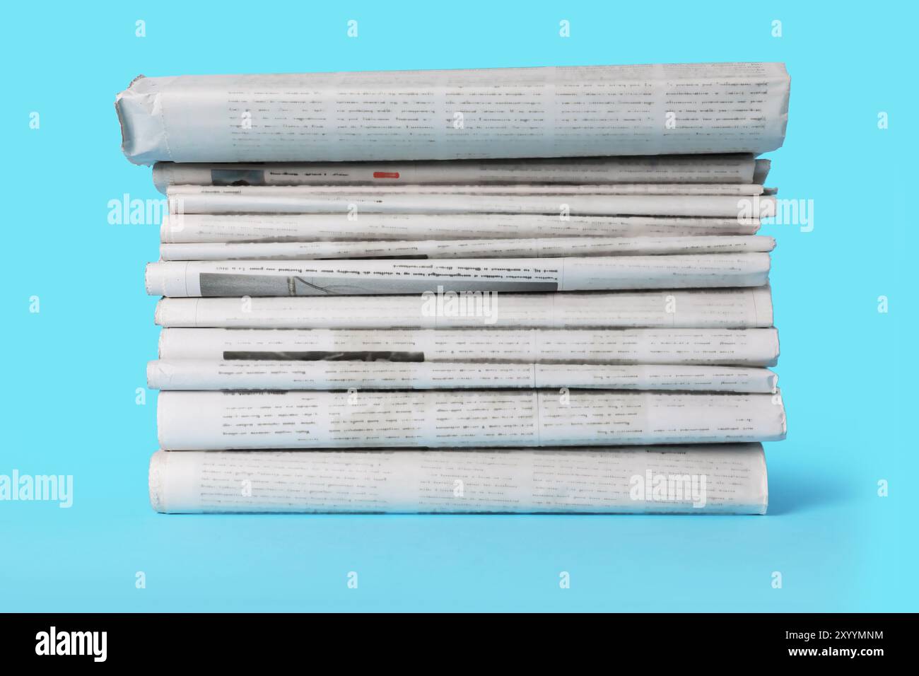 Stack of newspapers in different languages on light blue background ...