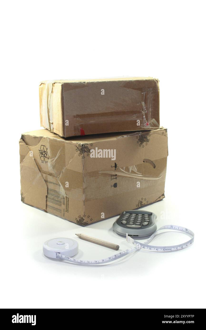 Boxes with pen, calculator and tape measure on a white background Stock ...