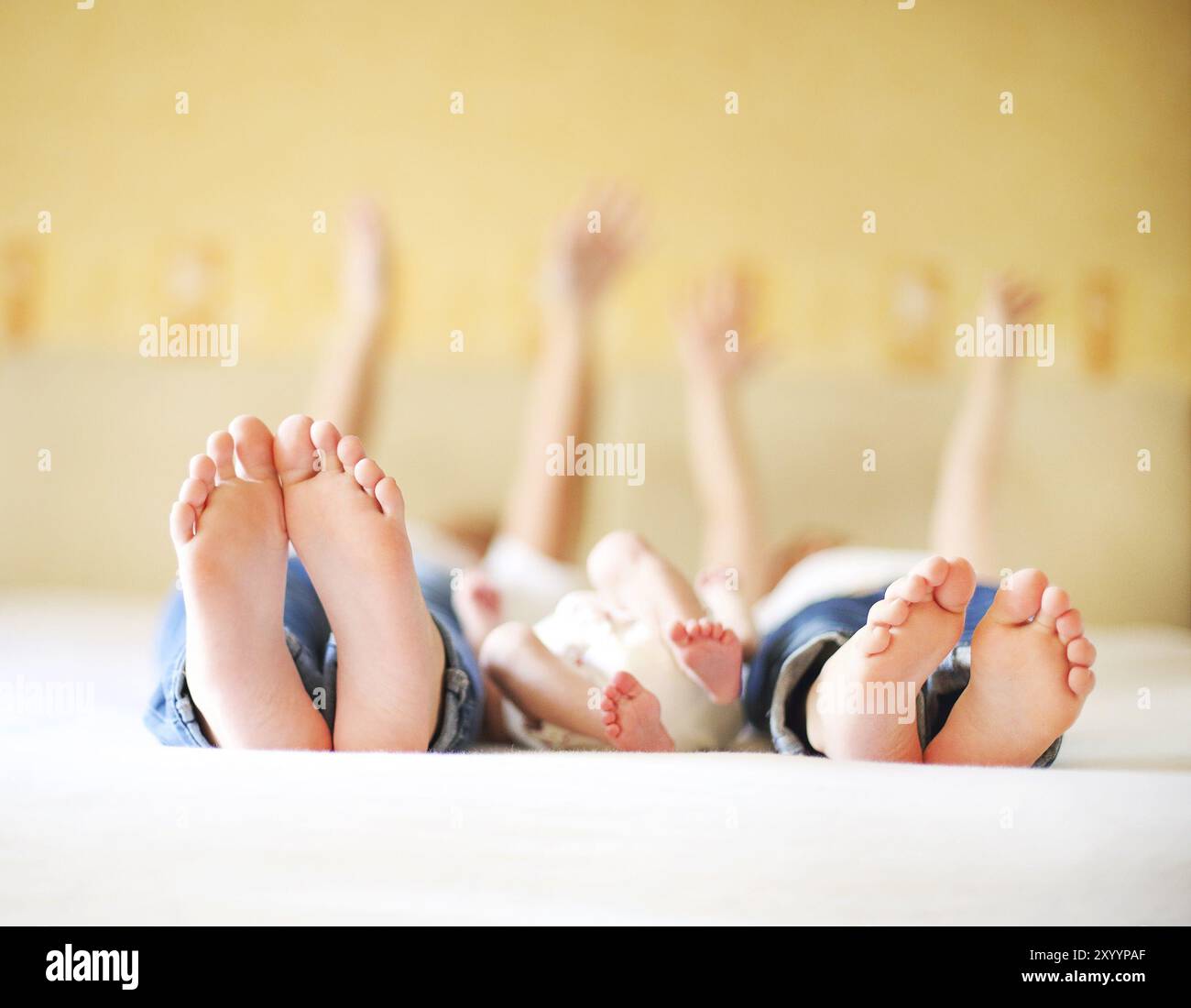 Sweet family in bed. Three sisters, close up on feet. Holiday and ...