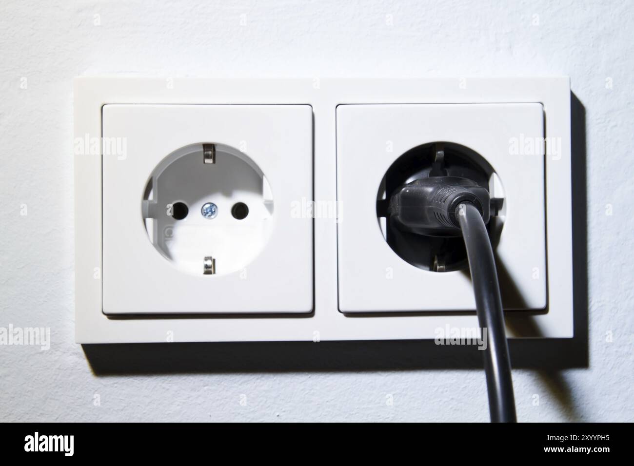 Double socket outlet with plug on white wall Stock Photo - Alamy