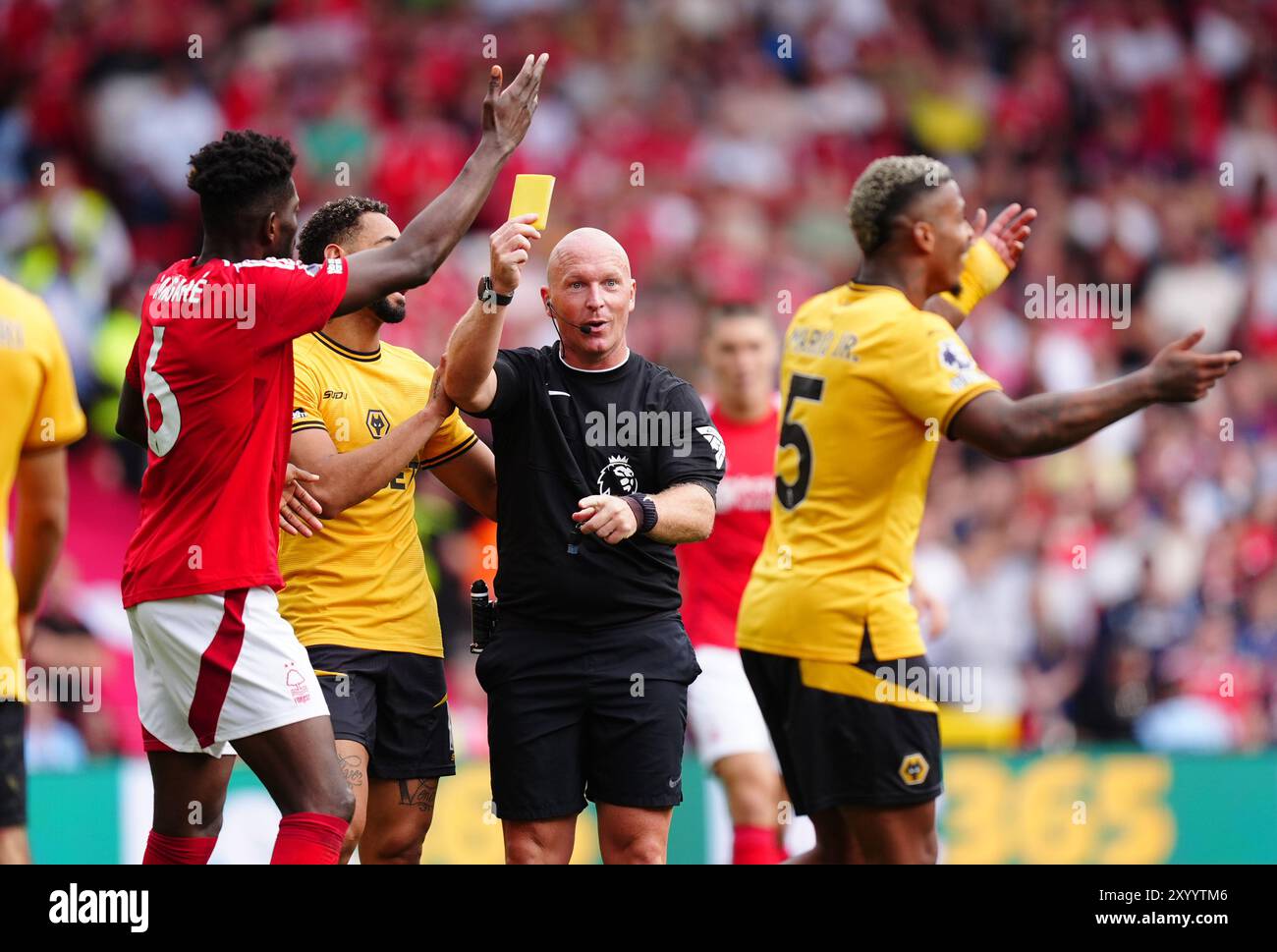 Referee Simon Hooper shows a yellow card to Wolverhampton Wanderers ...