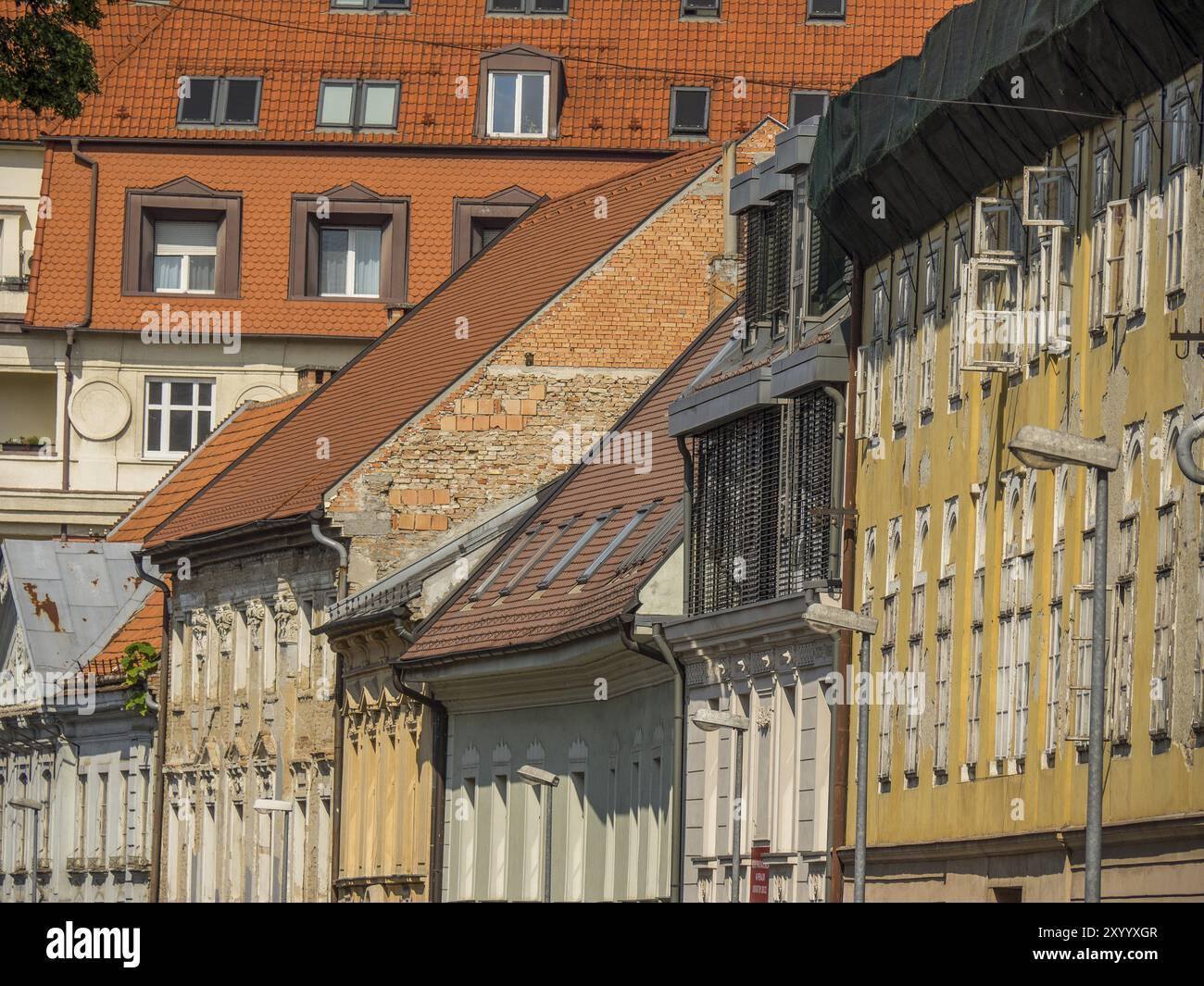 A row of old buildings with crumbling facades and red roofs in the old ...