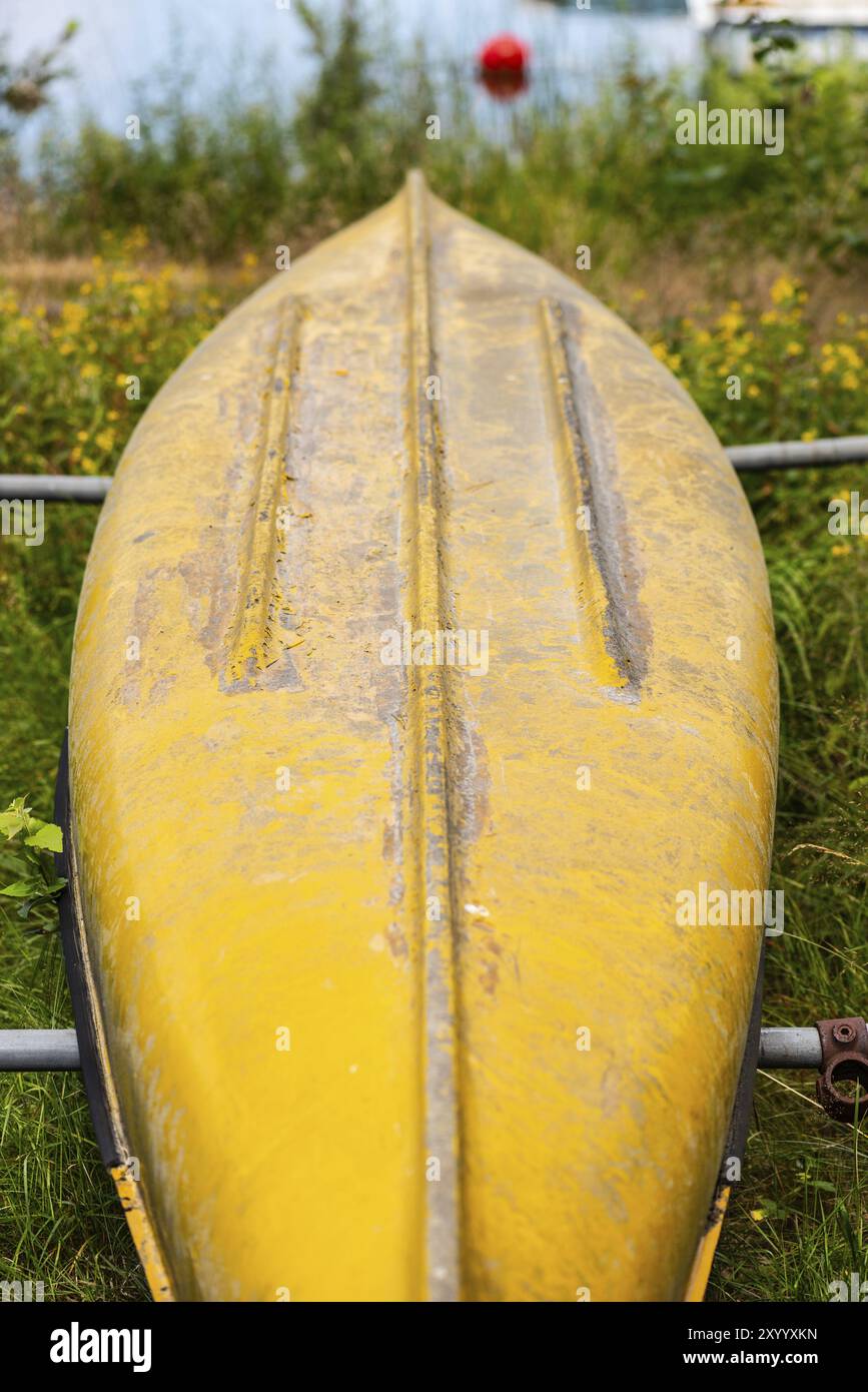 Yellow canoe lying upside down Stock Photo - Alamy