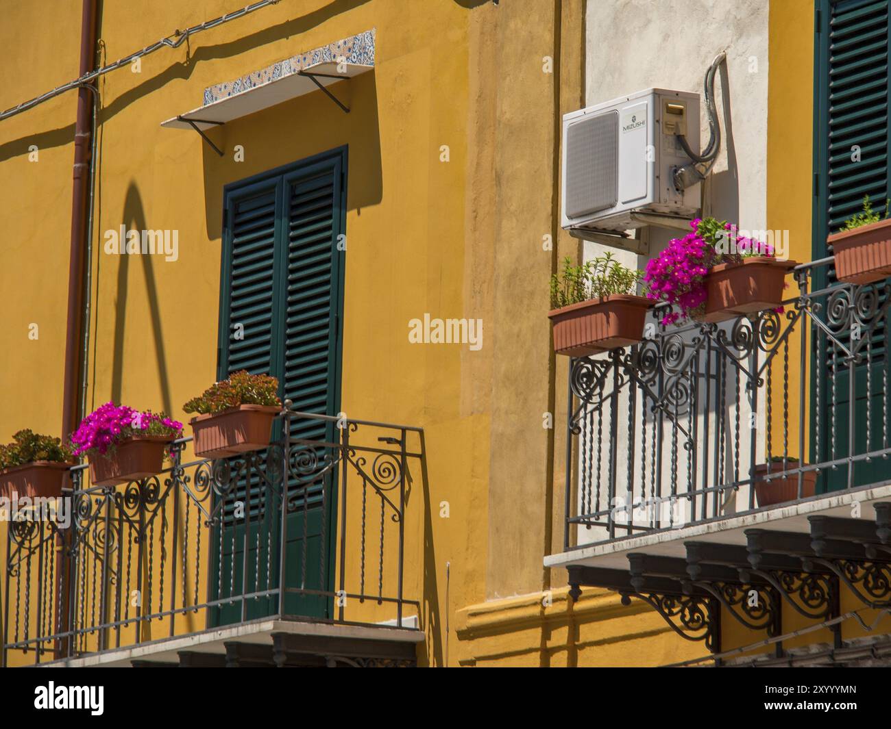 Mediterranean house with colourful flowers on balconies and green ...