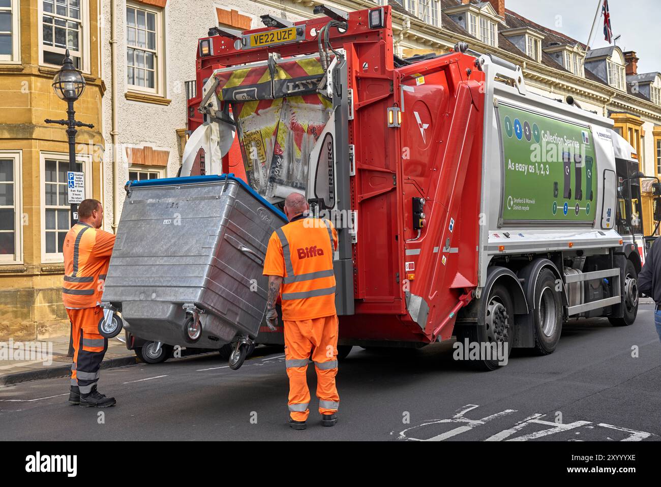Garbage collectors operating garbage truck for waste disposal. England ...