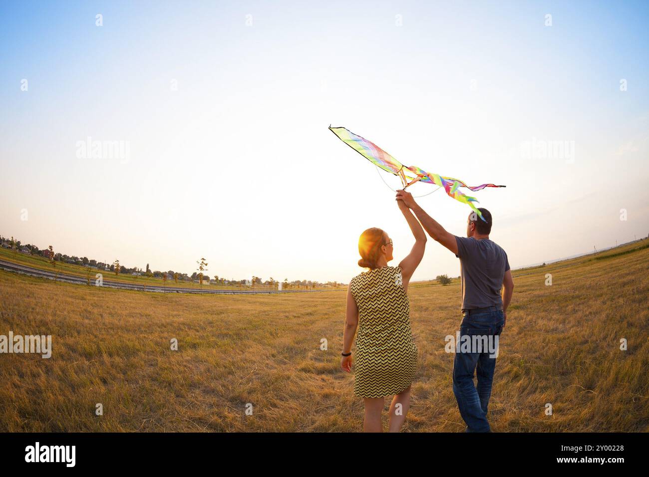 Happy young couple in love with flying a kite Stock Photo - Alamy