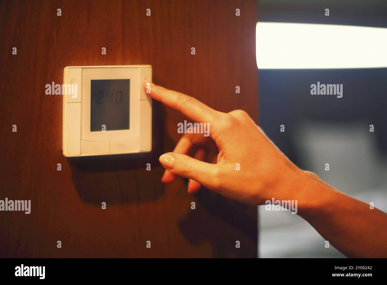 Hand turning on digital climate control. Close up Stock Photo - Alamy